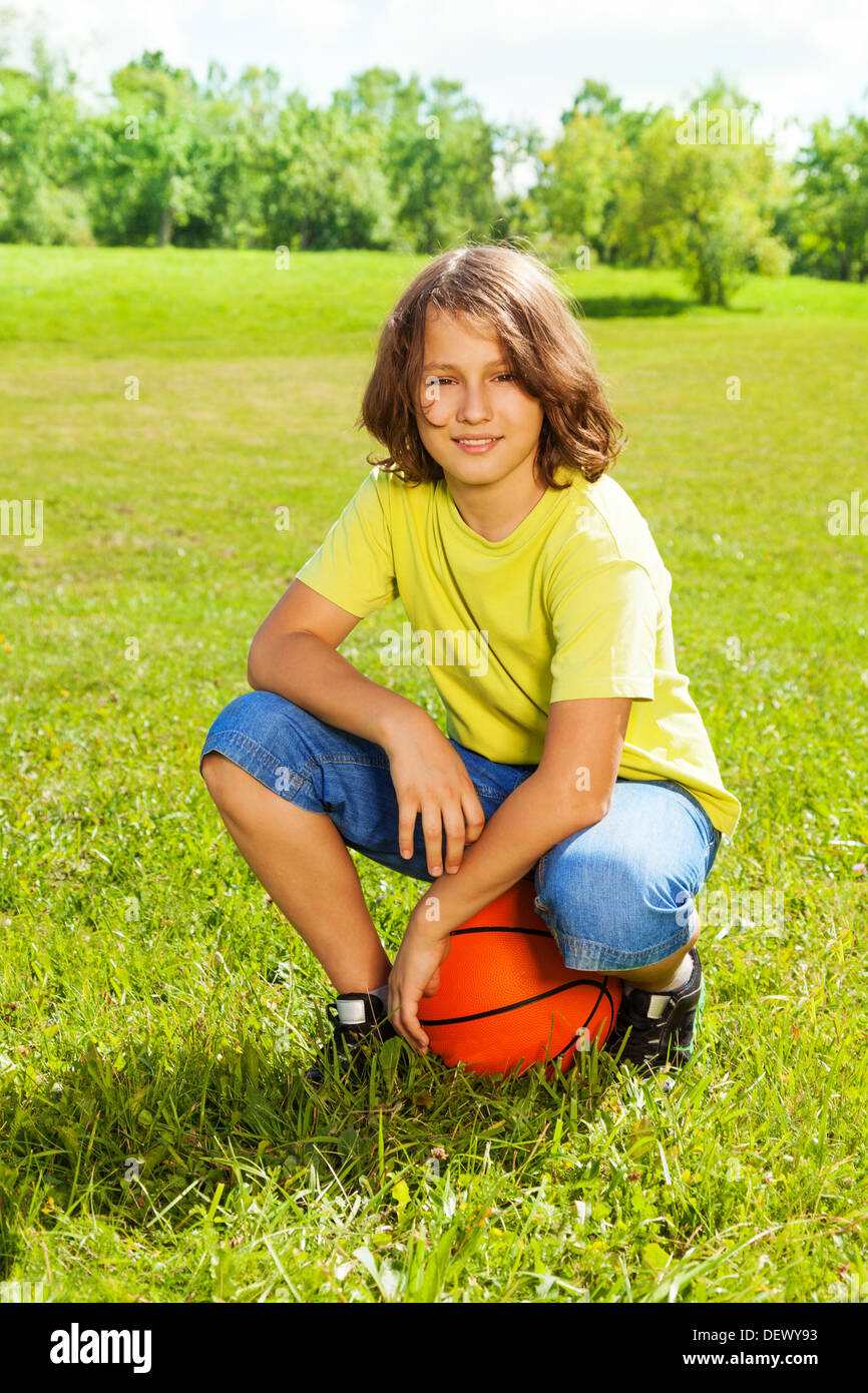 Portrait of 12 years old happy smiling boy sit on squads with ...
