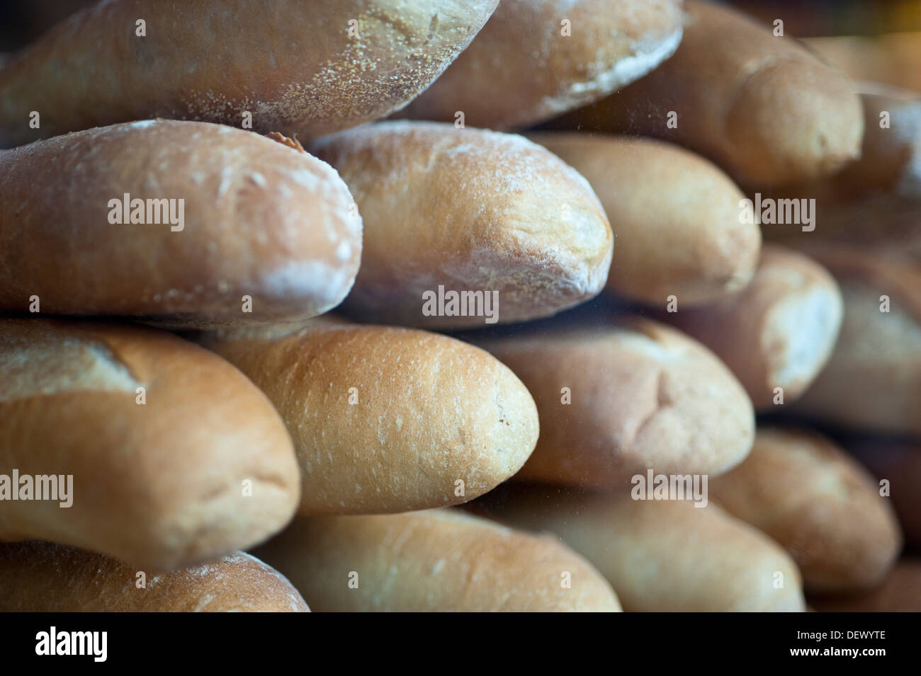 A display of French bread loaves in a store window, New York City, USA ...