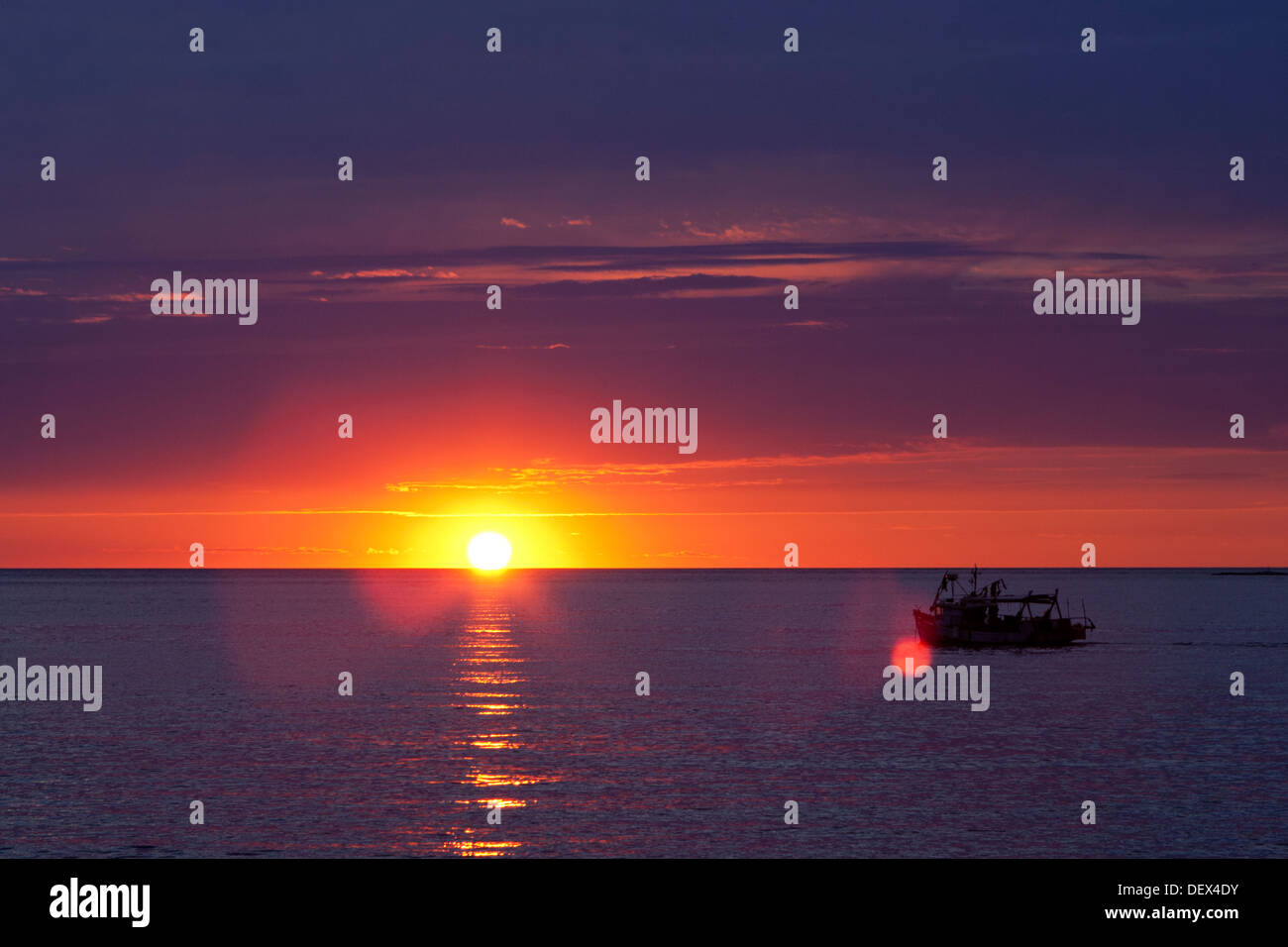 Croatian sunset near Rovinj. Single boat floating against the sunset ...