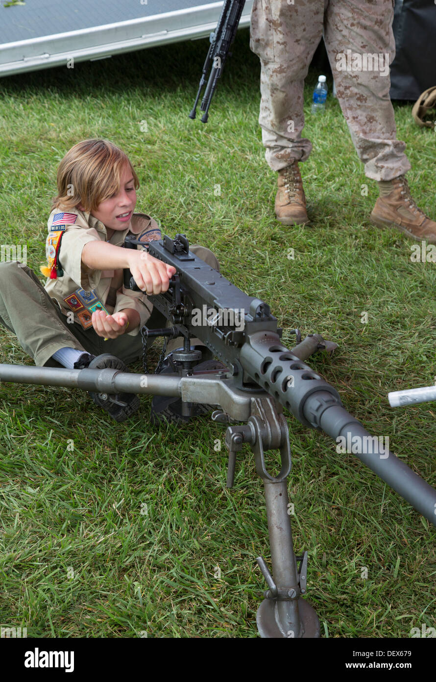 A Boy Scout handles a weapon at a Marine Corps booth during a weekend ...