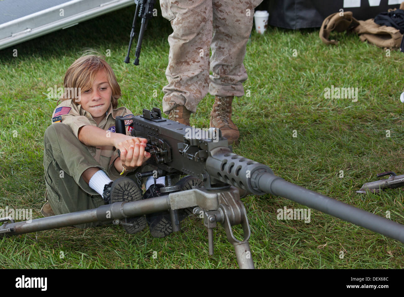 A Boy Scout handles a weapon at a Marine Corps booth during a weekend ...