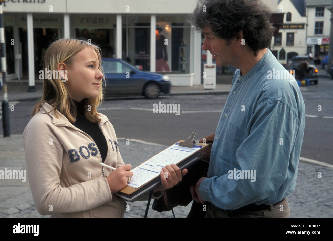 teenage girl with clipboard interviewing man in street Stock Photo - Alamy