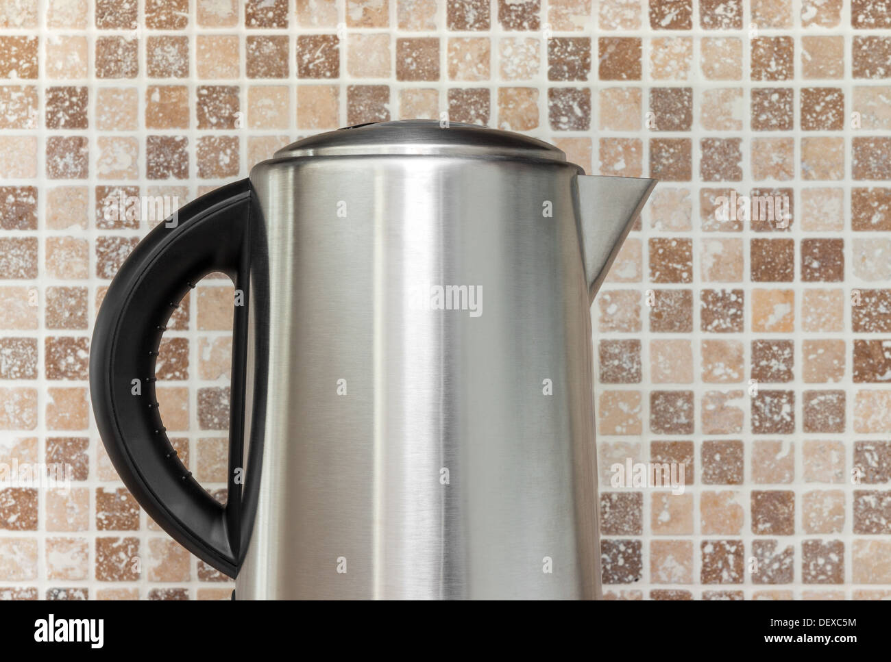 Metal electric kettle on kitchen tile background Stock Photo - Alamy