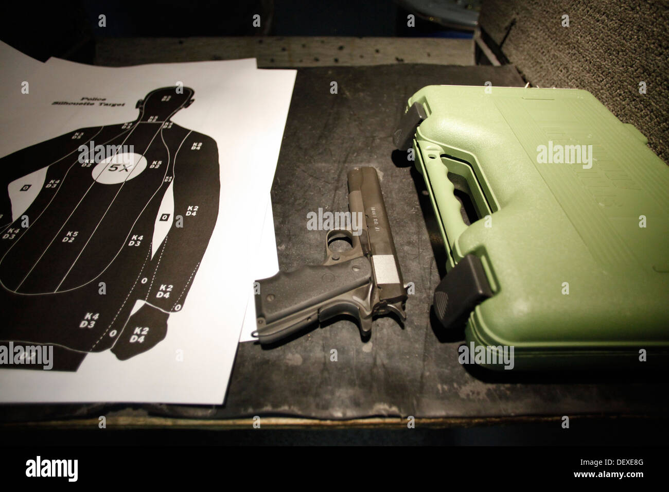 A target sits next to a 45 pistol at a booth inside an indoor gun range ...