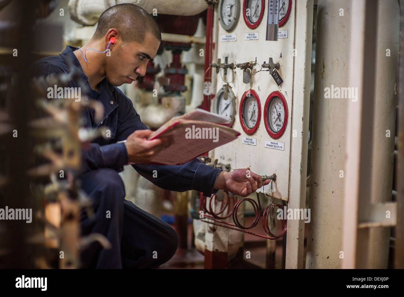 Engineman 3rd Class Arturo Mendoza checks valve pressure on watch ...