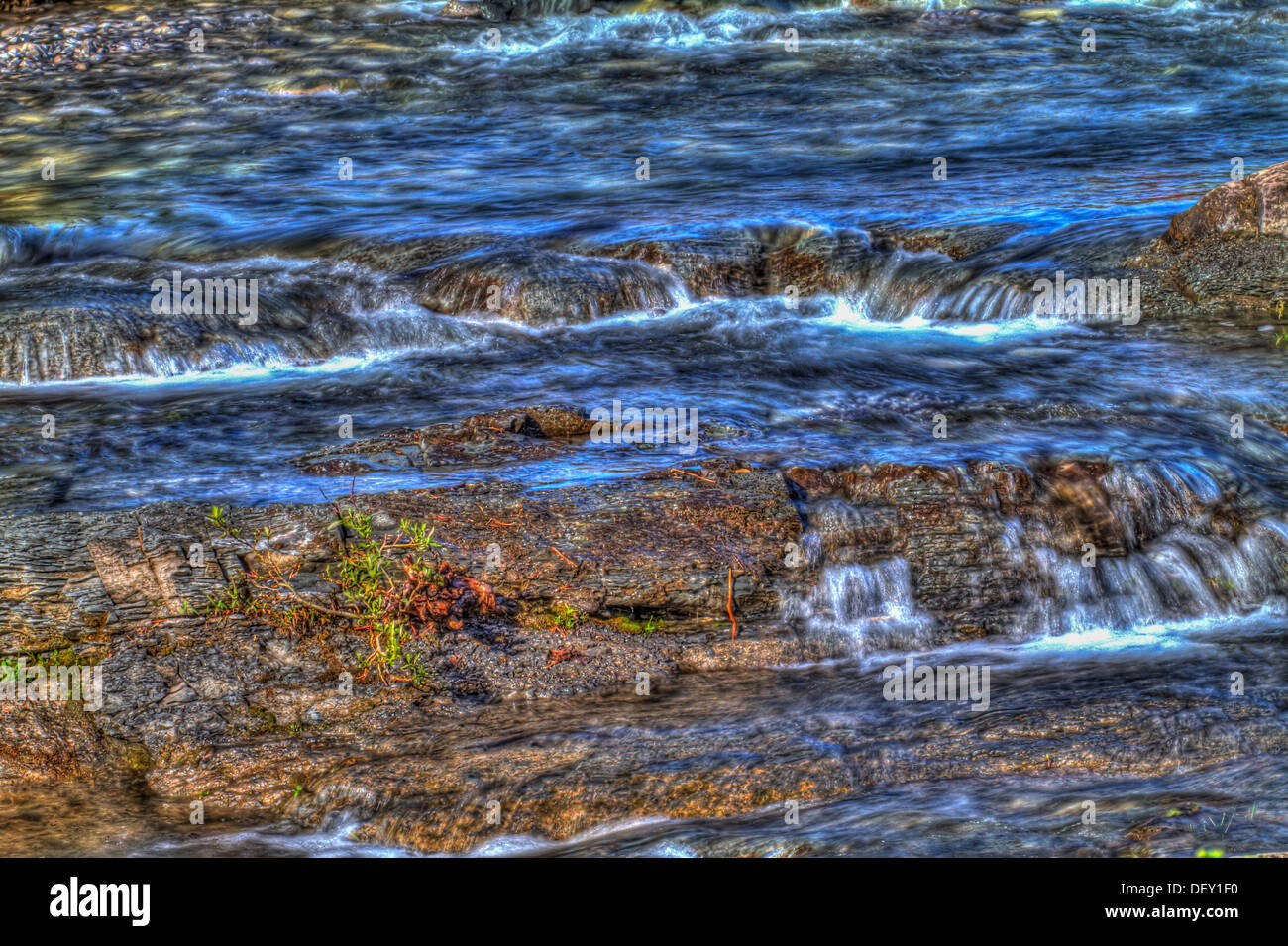 Landscape scenery of deep, rich blue, flowing water cascading over ...