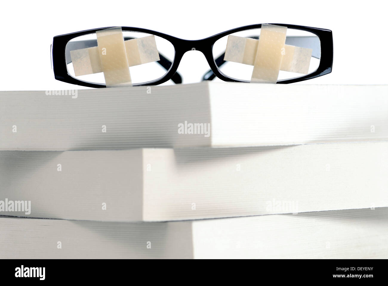 Glasses with plasters on pile of books, symbolic image for students ...