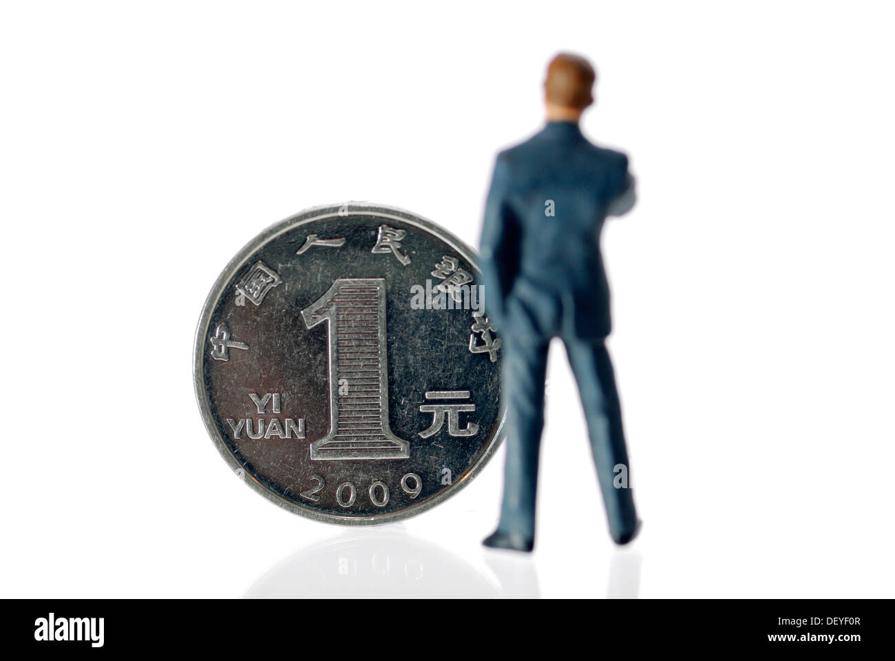 Miniature figure of a businessman in front of a Chinese one-yuan coin ...