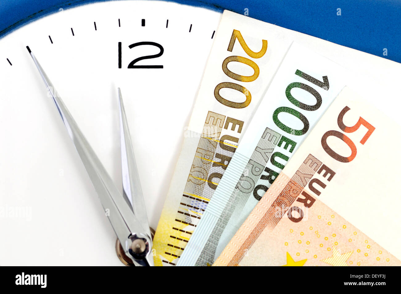 Clock showing almost high noon with banknotes Stock Photo - Alamy