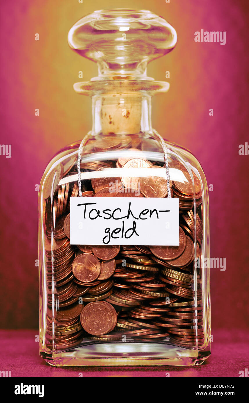 Glass jar filled with euro cent coins, labelled Taschengeld, German for ...