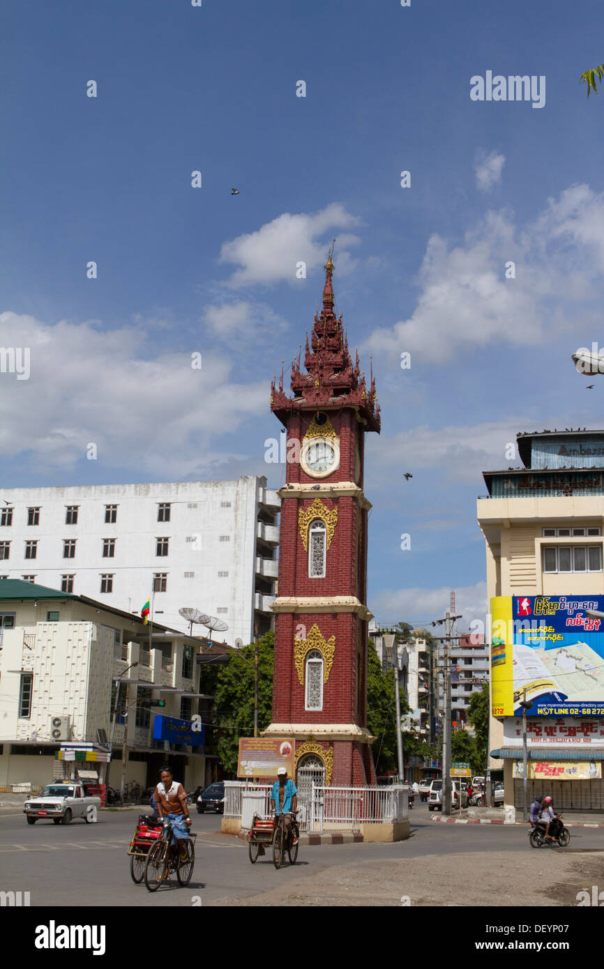 People ride past the Clock Tower in central Mandalay Stock Photo - Alamy
