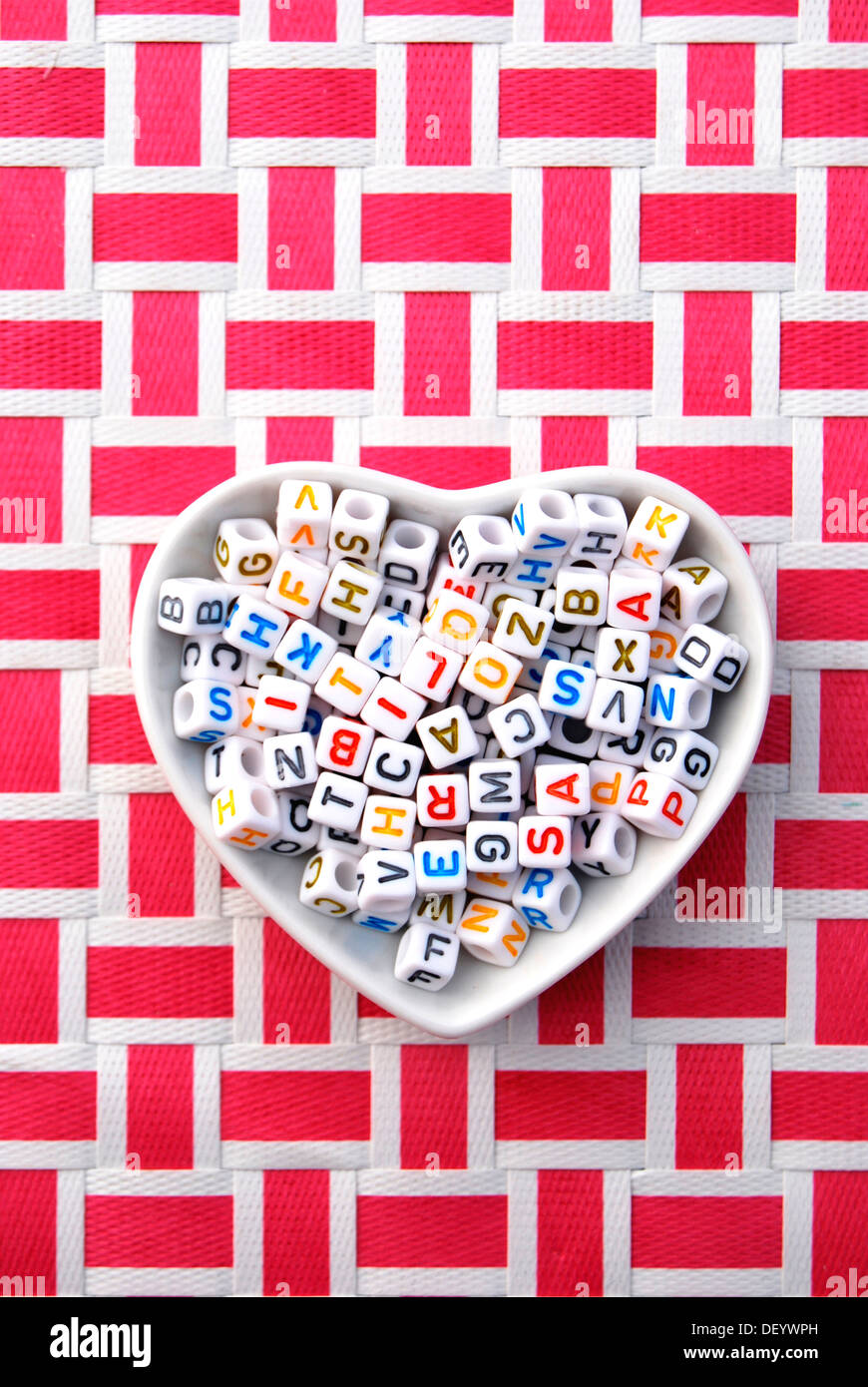 Beads, letter cubes in a heart-shaped bowl Stock Photo - Alamy