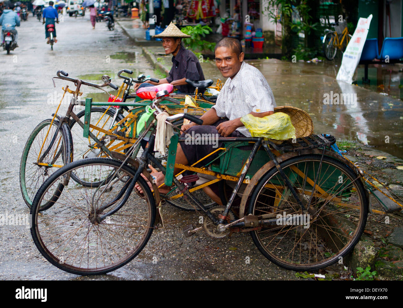 Rickshaw drivers sit on their bikes along the Main Road in Sittwe ...