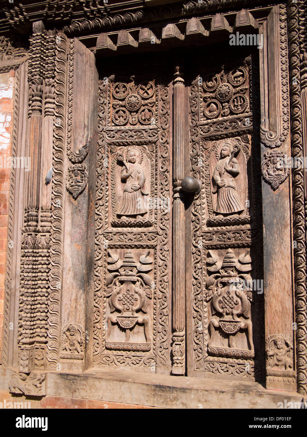 A carved door to a temple is lit by midday sun in Bhaktapur, Nepal ...