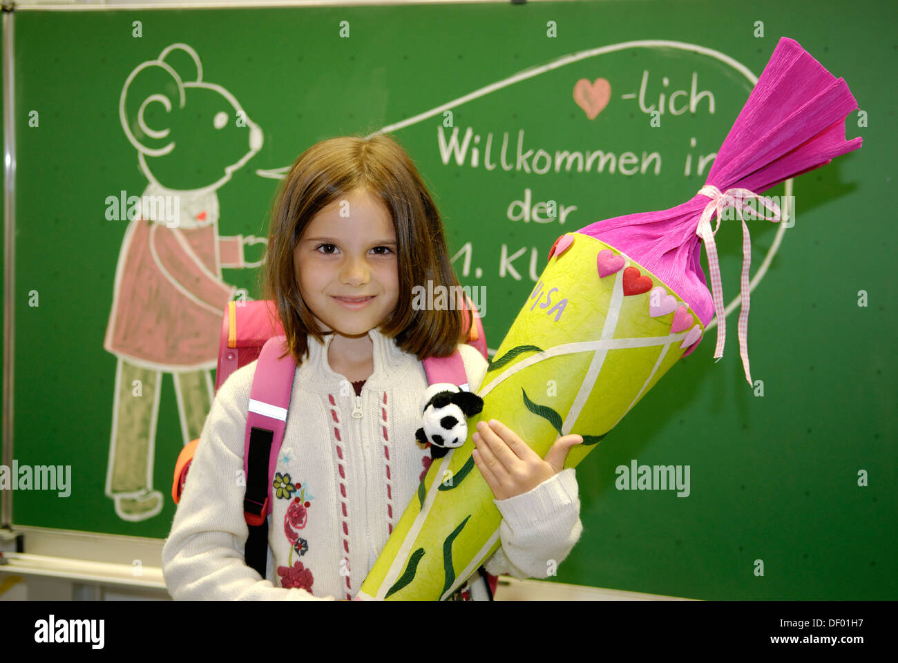 First grader at her first day at school in front of the blackboard ...