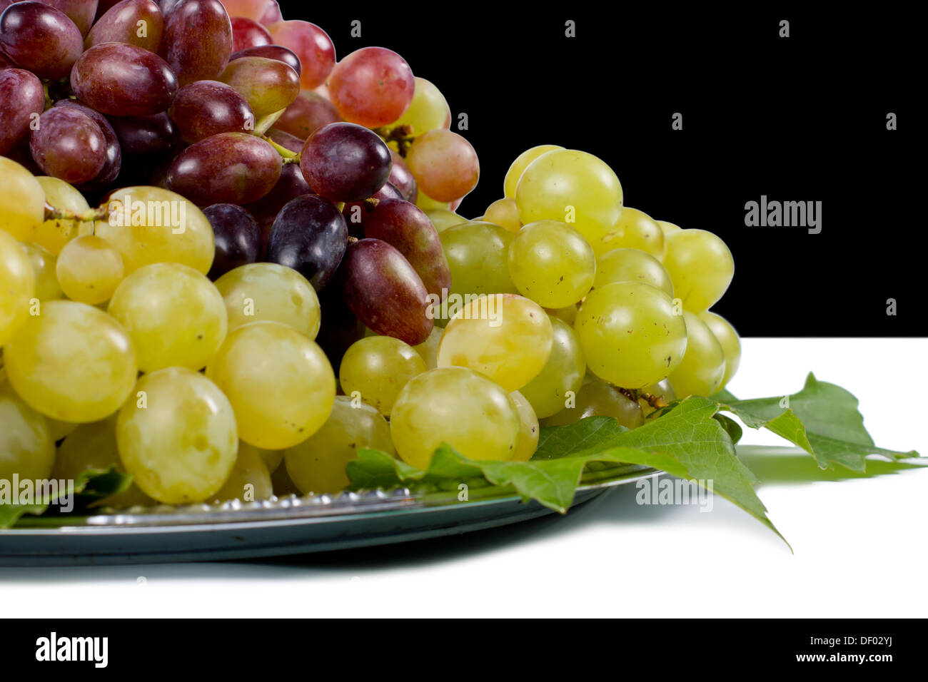 Close up side view of bunches of fresh ripe juicy red and green table ...
