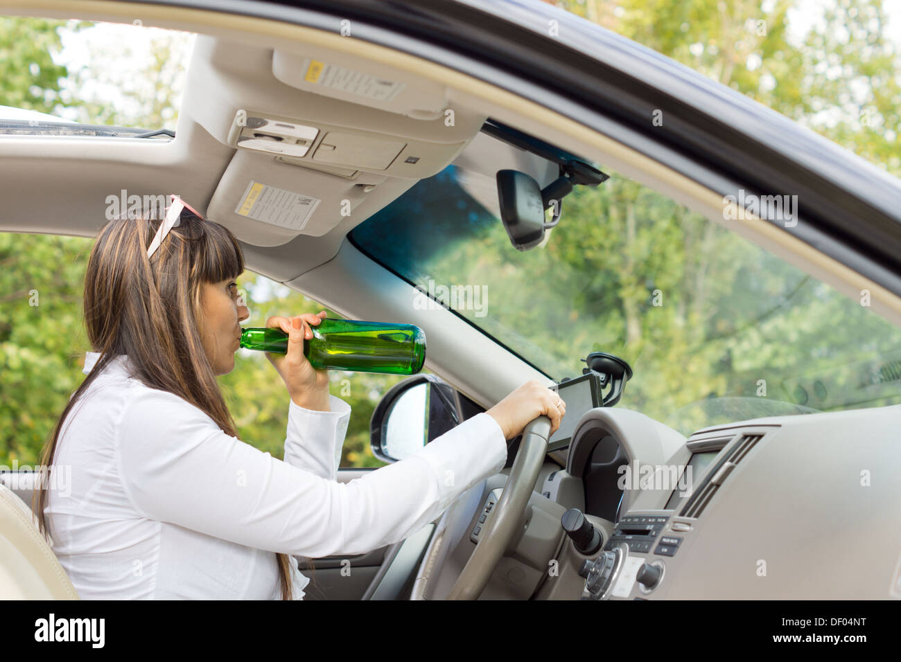 Side view from inside the vehicle of an alcoholic woman driver drinking ...