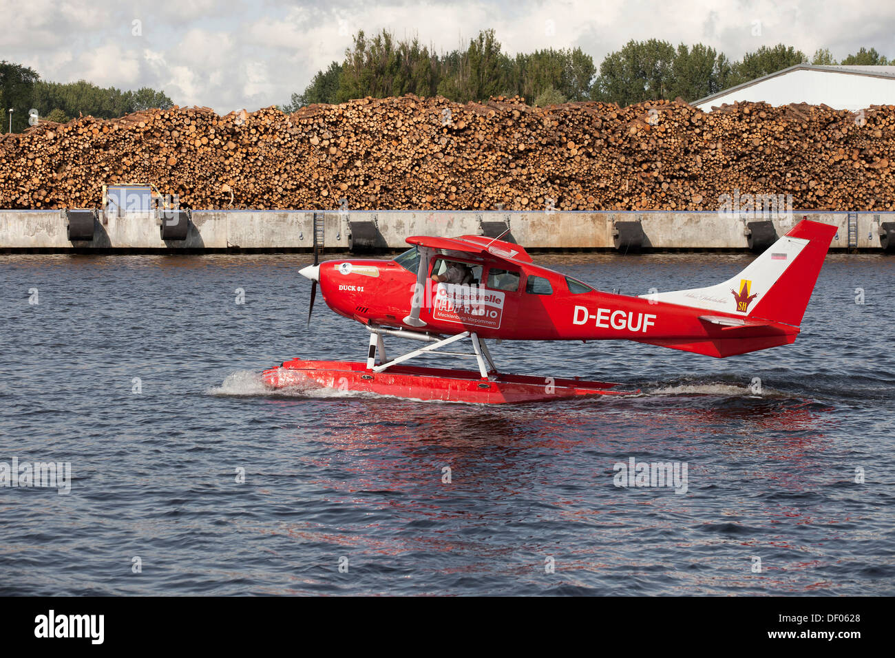Bright red seaplane, Duck 01, a Cessna 206, in the old fishing port of ...