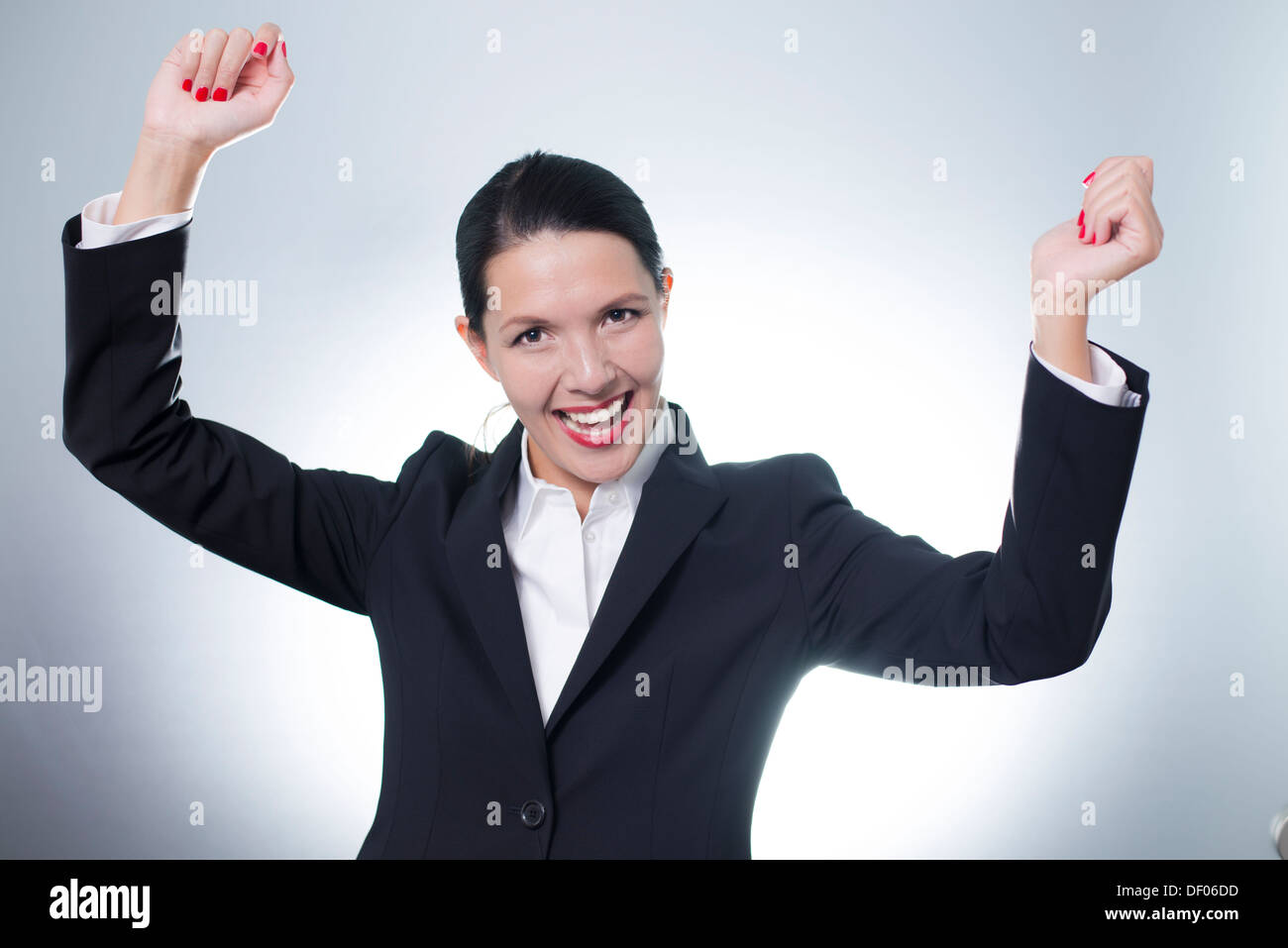 Beautiful jubilant young businesswoman cheering with a beaming ...