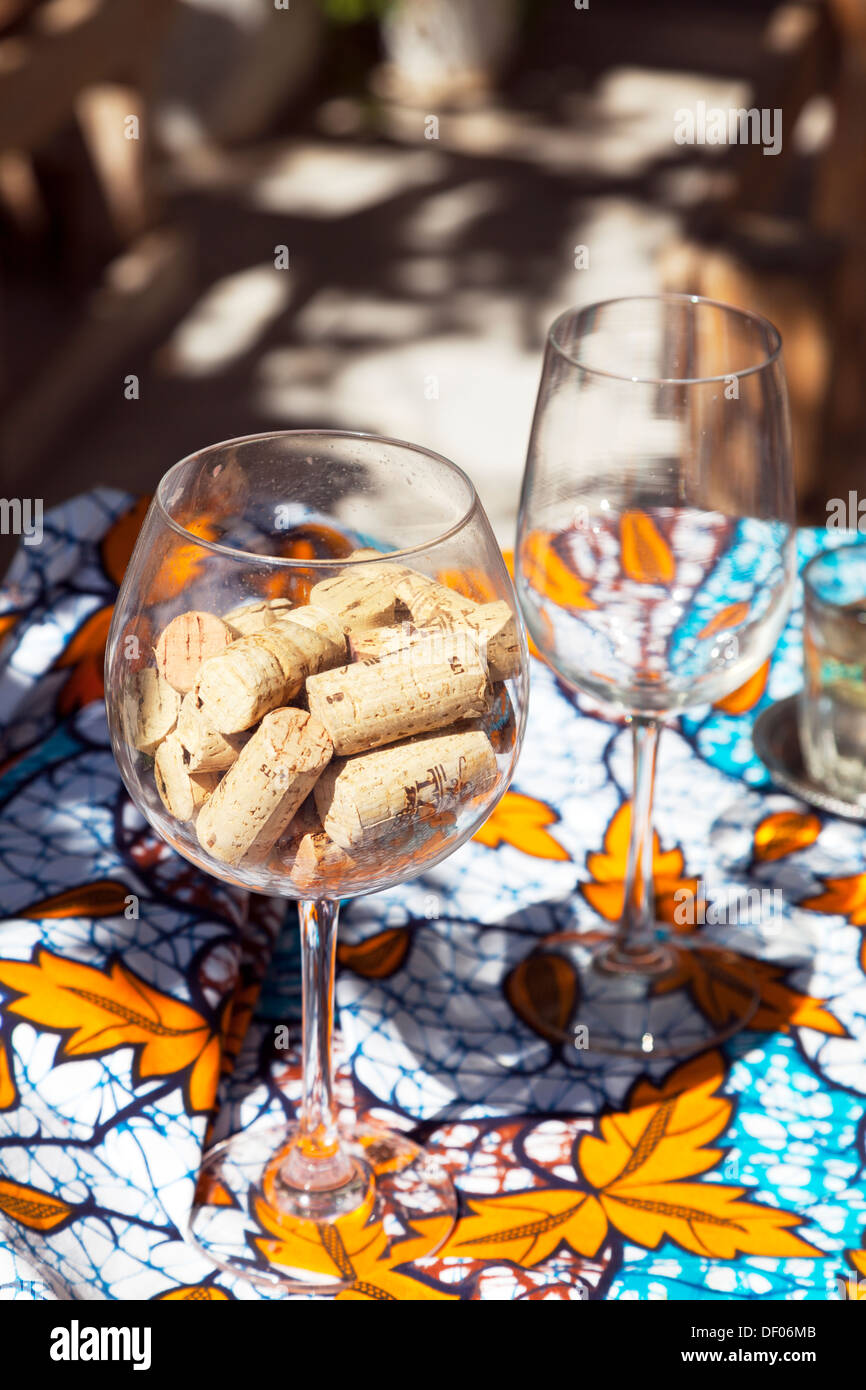 corks from a wine bottle inside in a glass next to empty glass Nidri ...