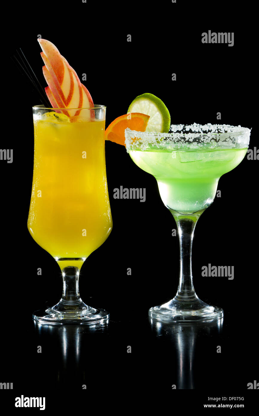 cocktails with bright colors isolated on a black background garnished ...