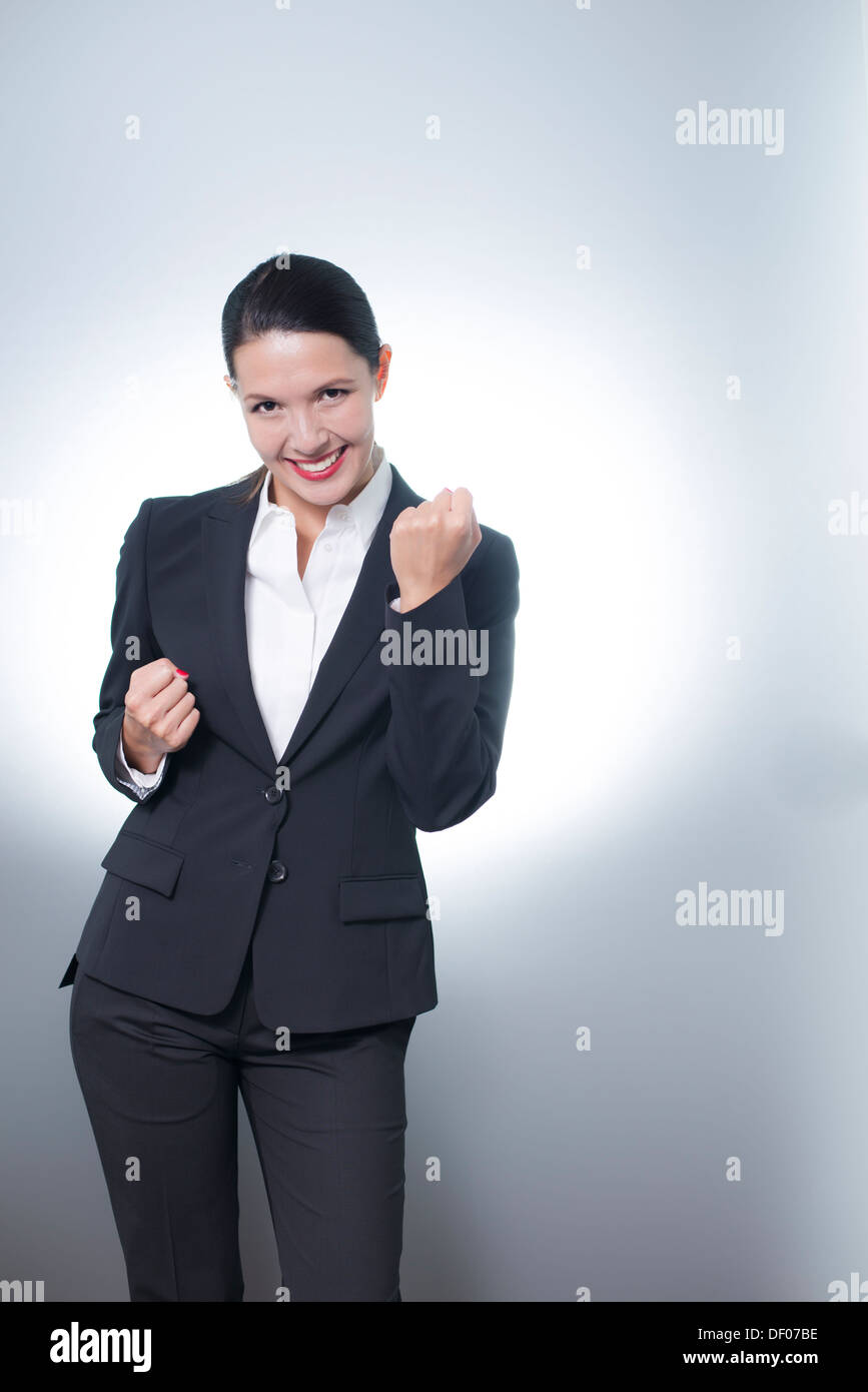 Beautiful jubilant young businesswoman cheering with a beaming ...