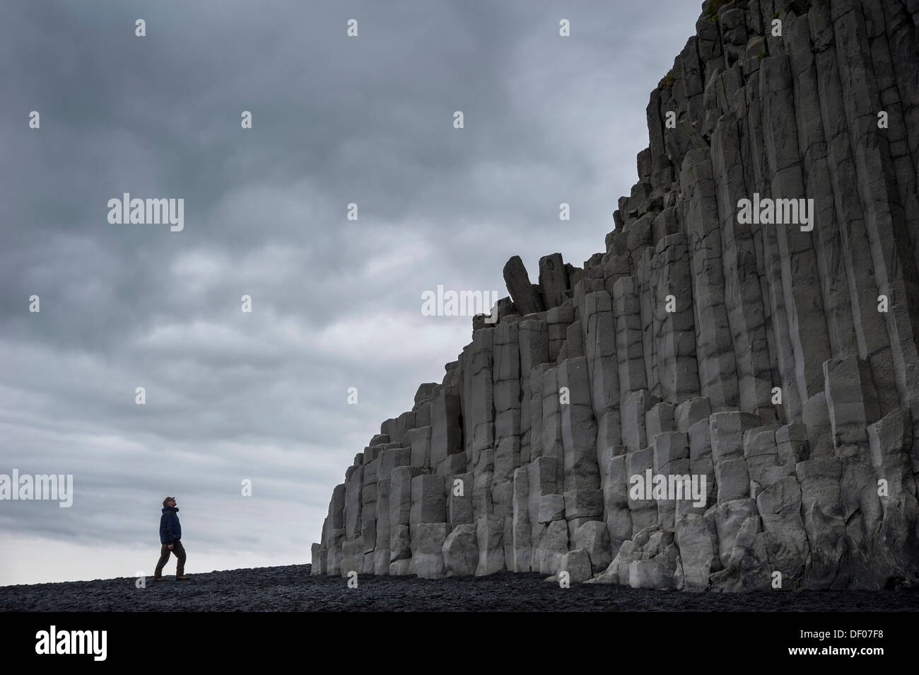 Man looking at basalt columns, Reynisfjara beach, a black beach near ...