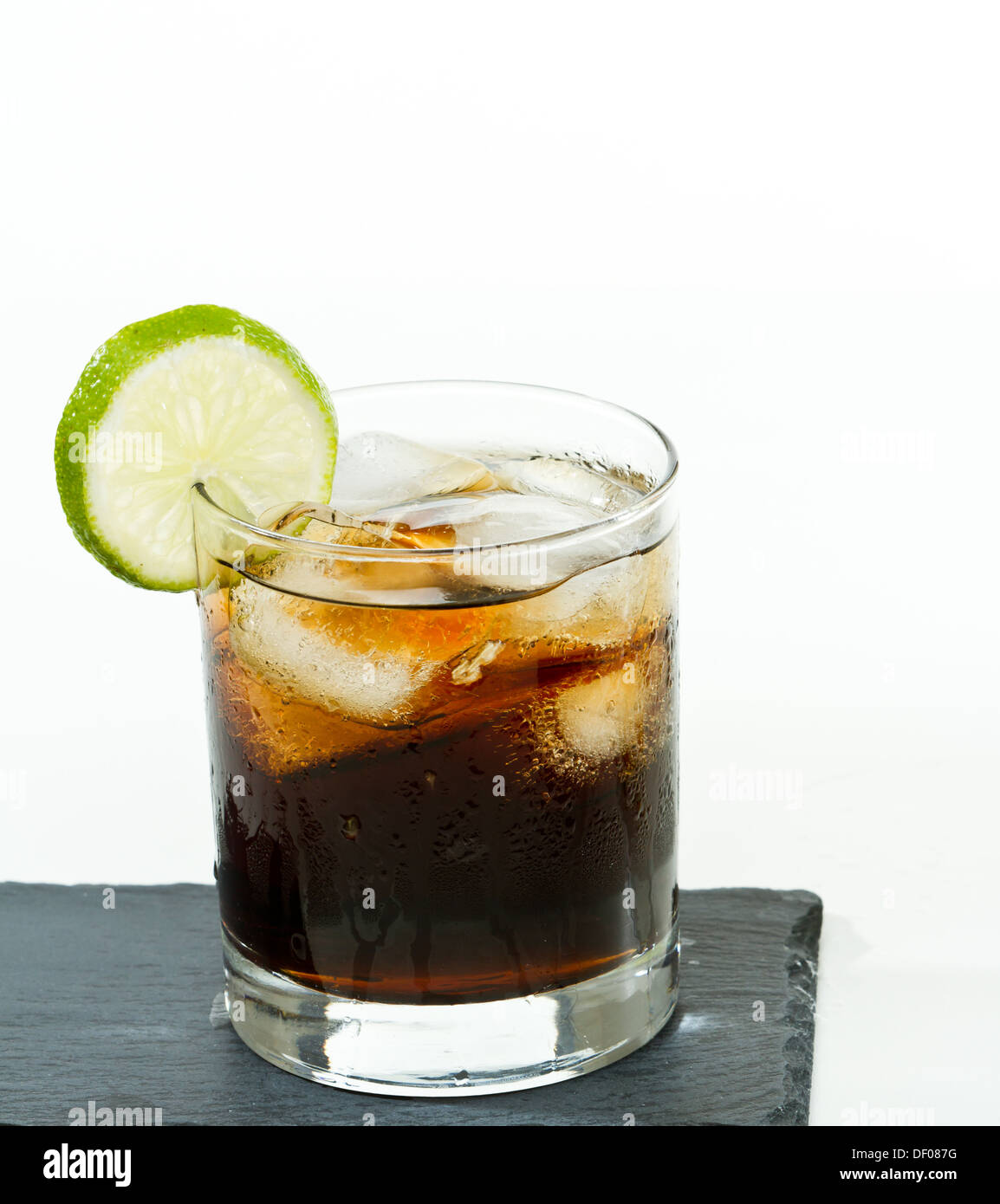 rum and cola with a lime garnish isolated on a white background Stock ...