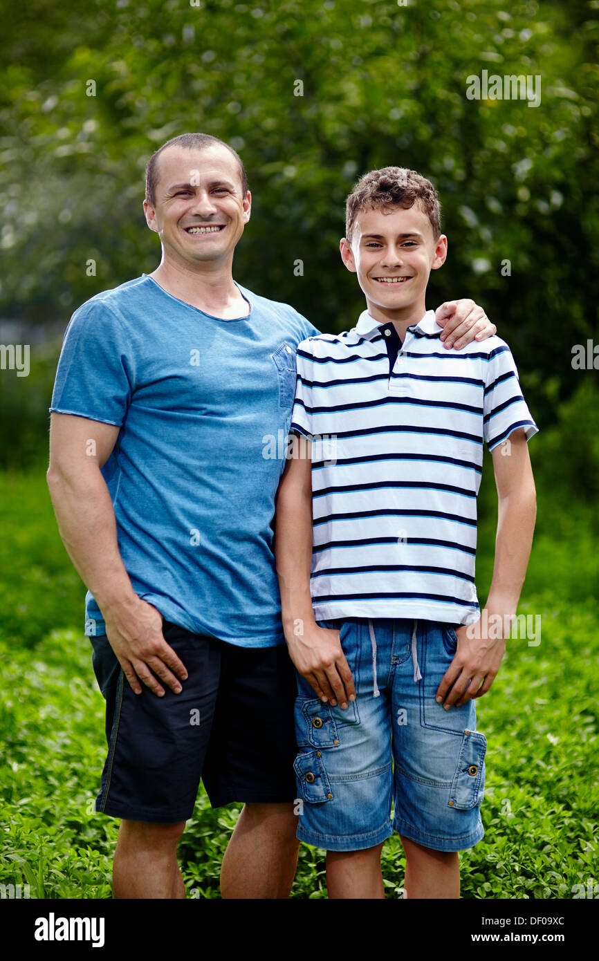 Father and his teenage son in a clover field near the orchard Stock ...