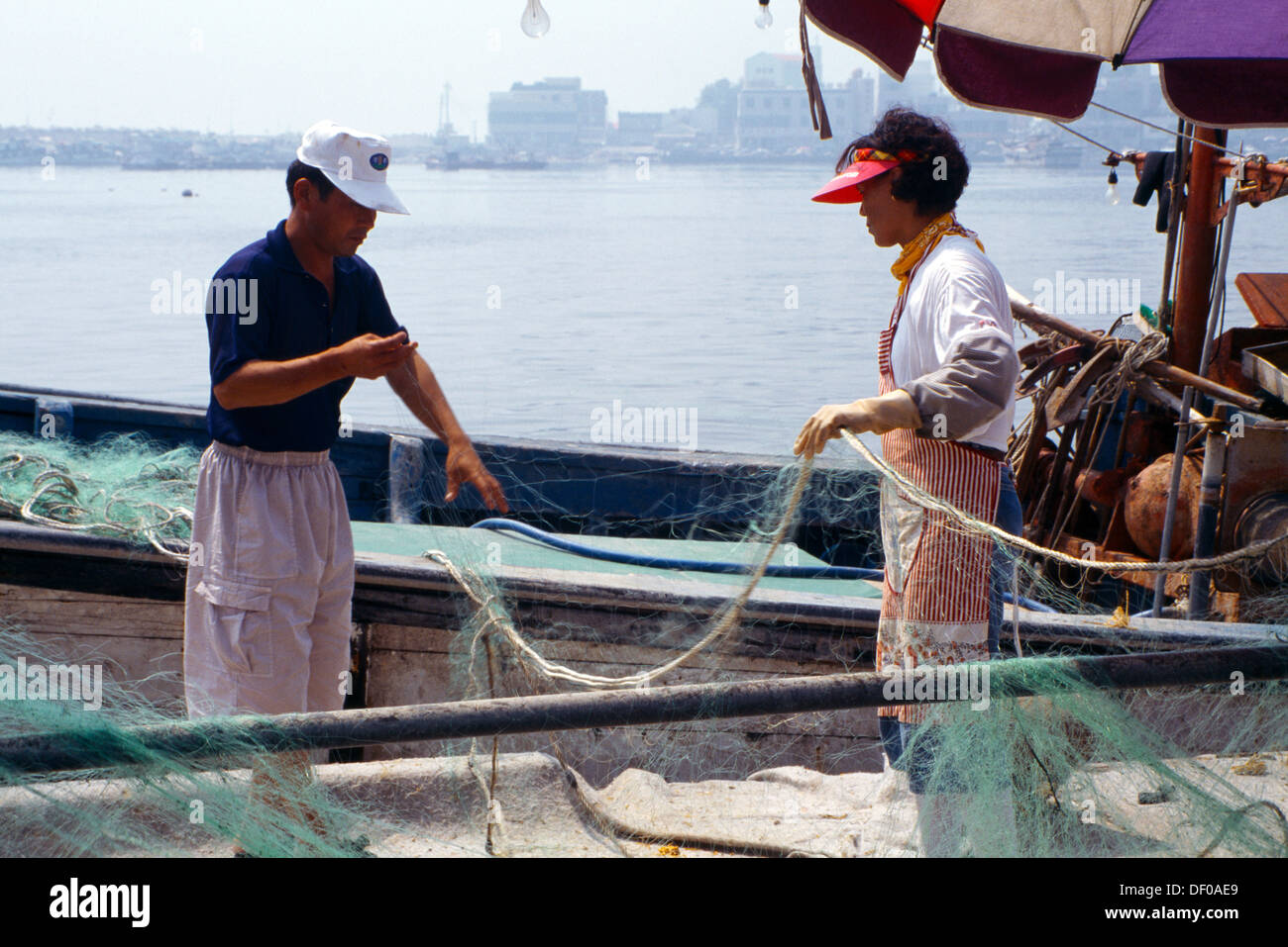 Woman repairing fishing nets hi-res stock photography and images - Alamy