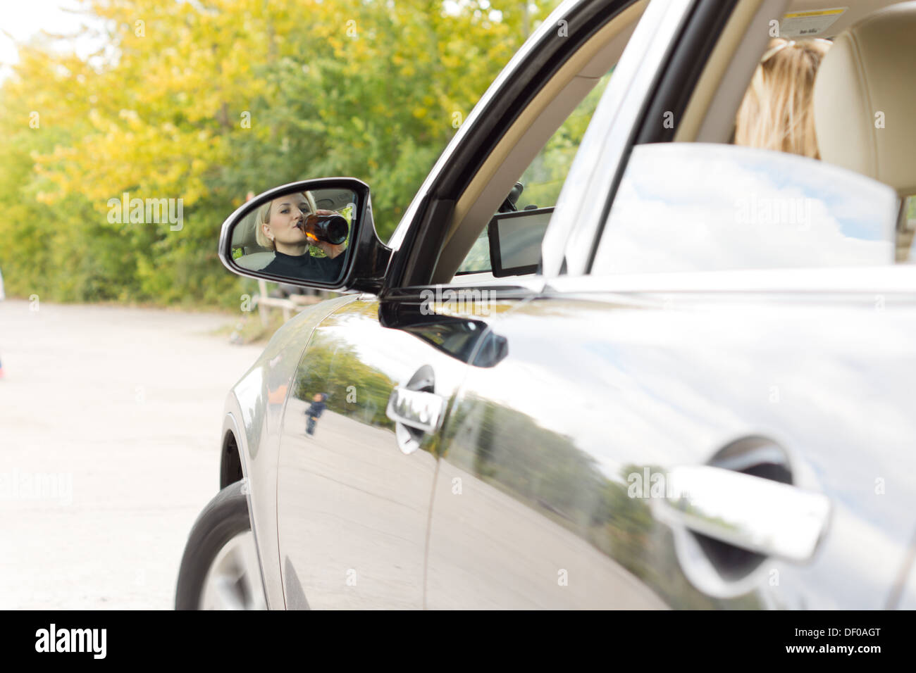 Woman weaving her car on the road as she drinks alcohol directly from a ...