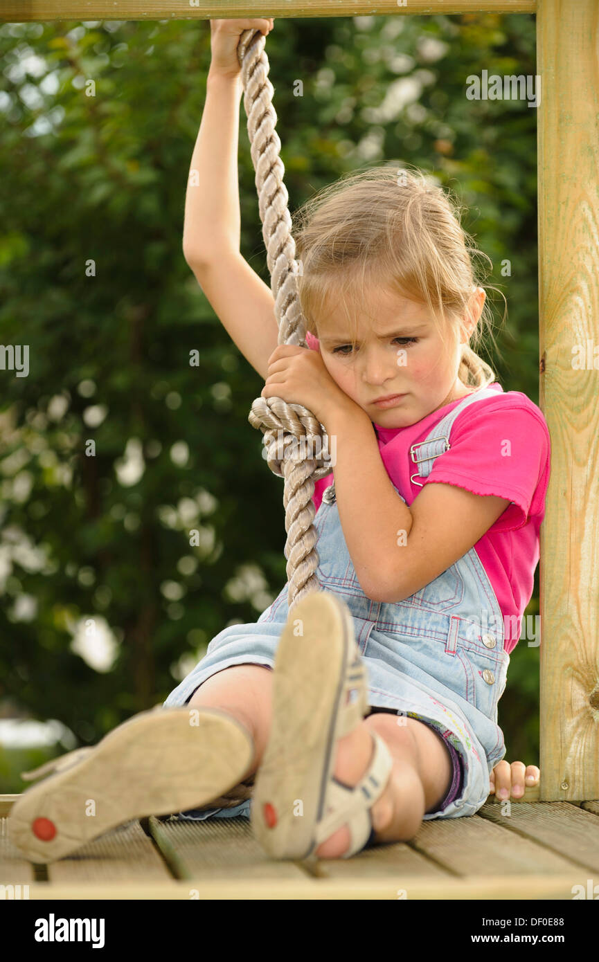 6-year-old girl afraid to climb down the rope of a play house Stock ...