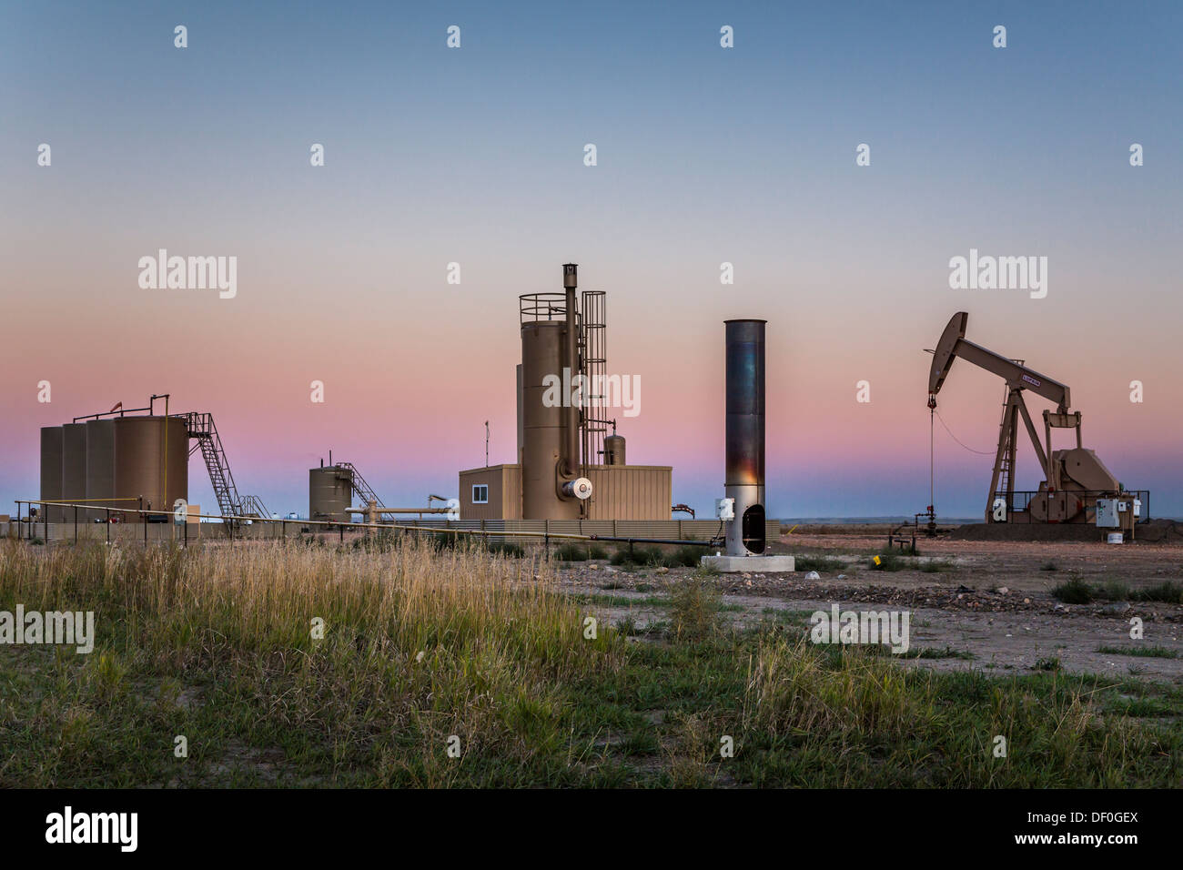 Oil pumpers in the Bakken play oil fields at sunset near Williston ...