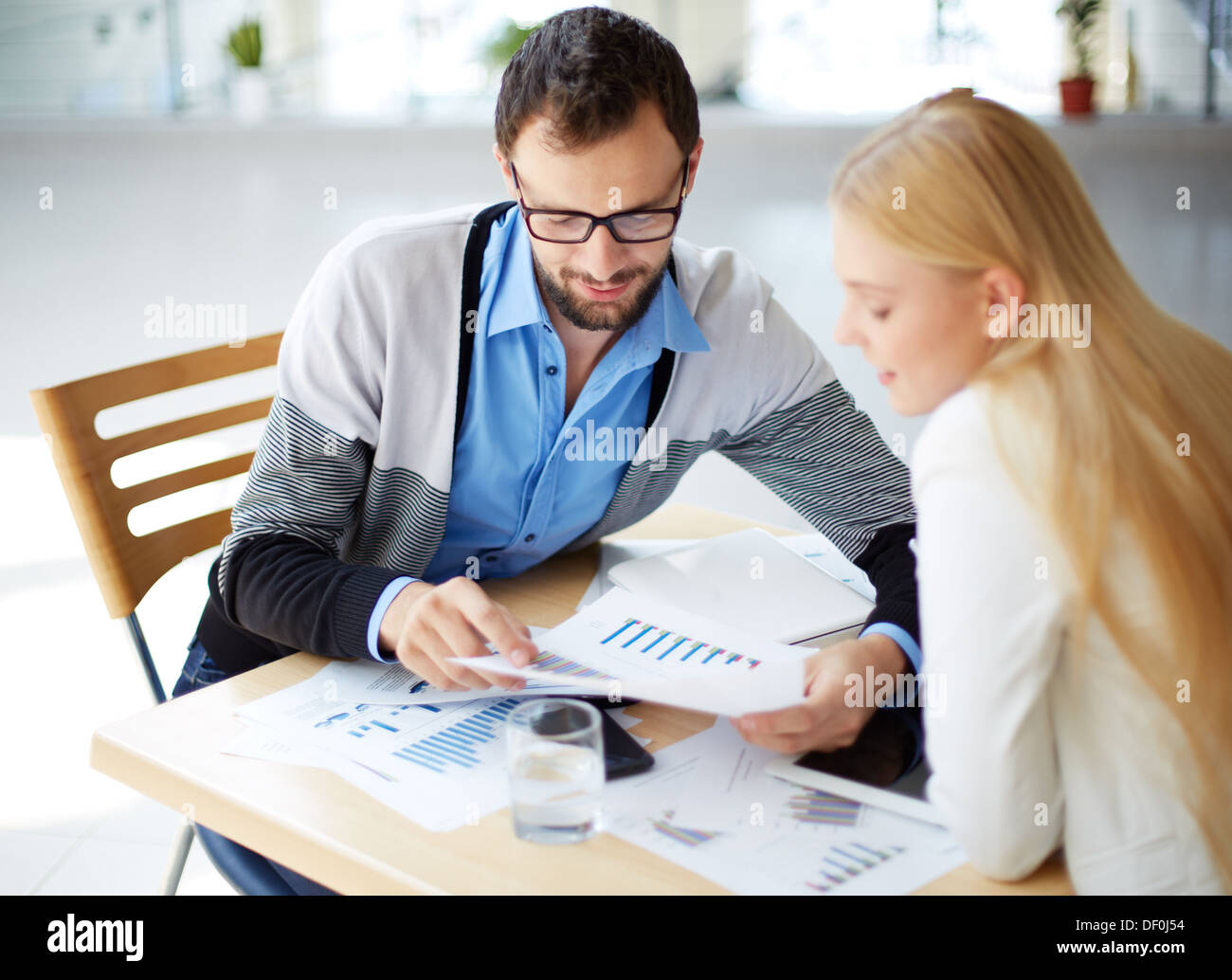 Two business people discussing documents at meeting Stock Photo - Alamy