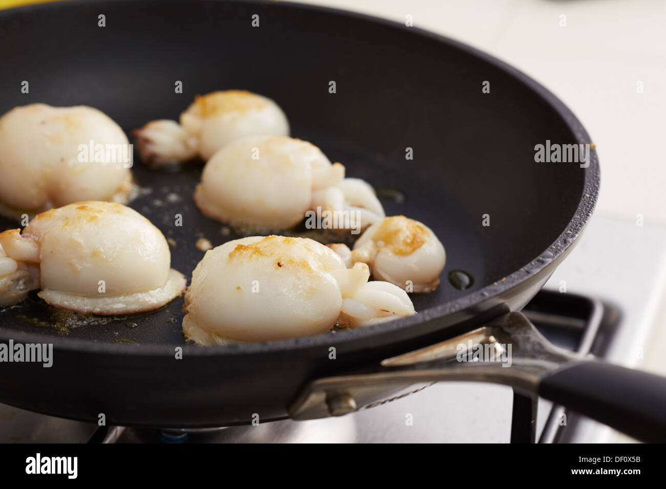 Preparing grilled cuttlefish in a pan close-up Stock Photo - Alamy