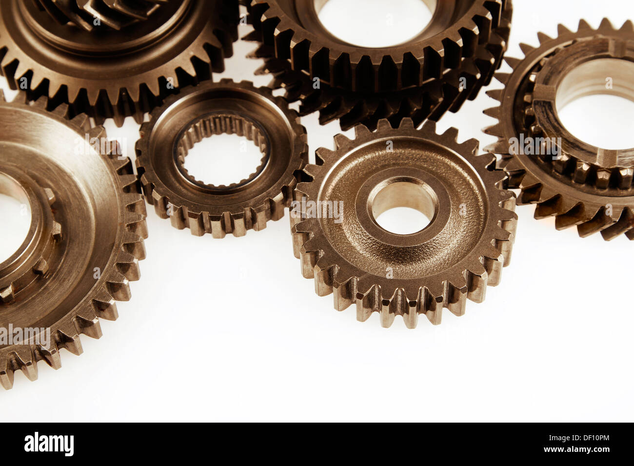 Metal cog wheels bonding together on plain background Stock Photo - Alamy