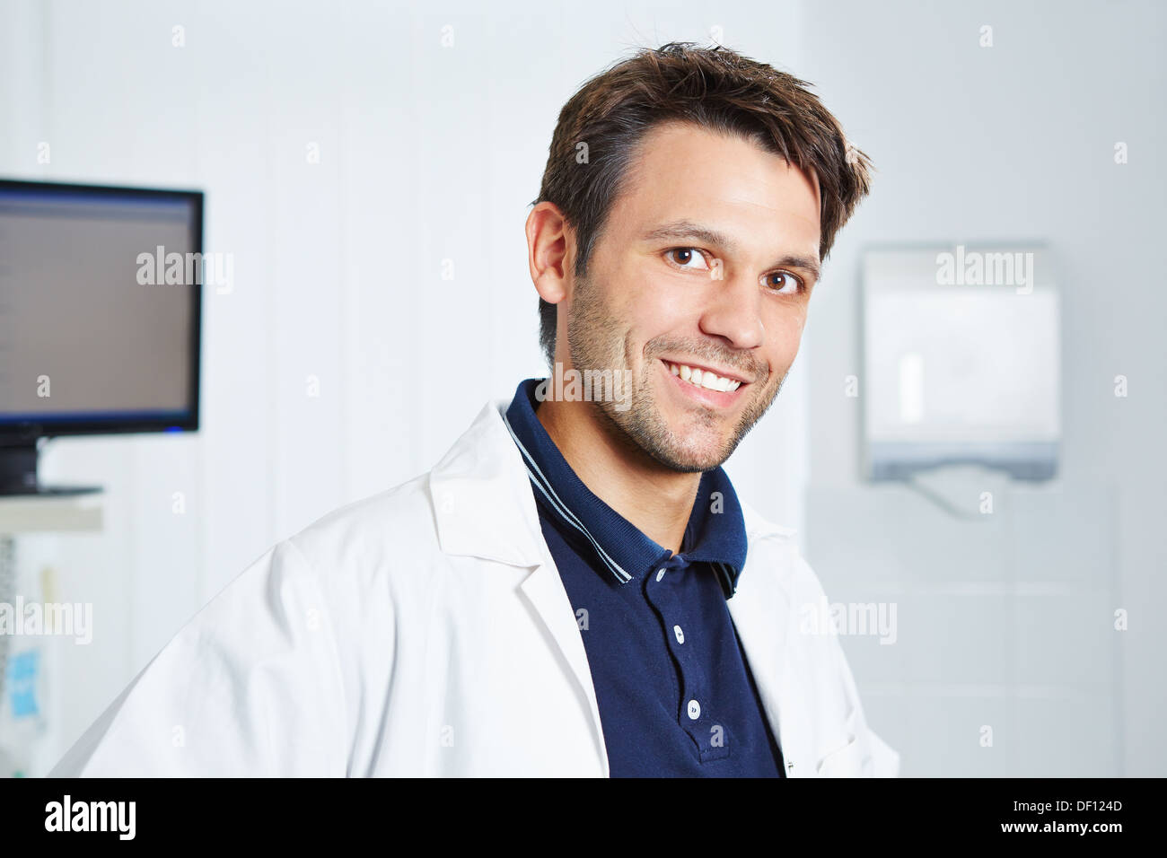 Portrait of a happy dentist in a white lab coat in dental practice ...