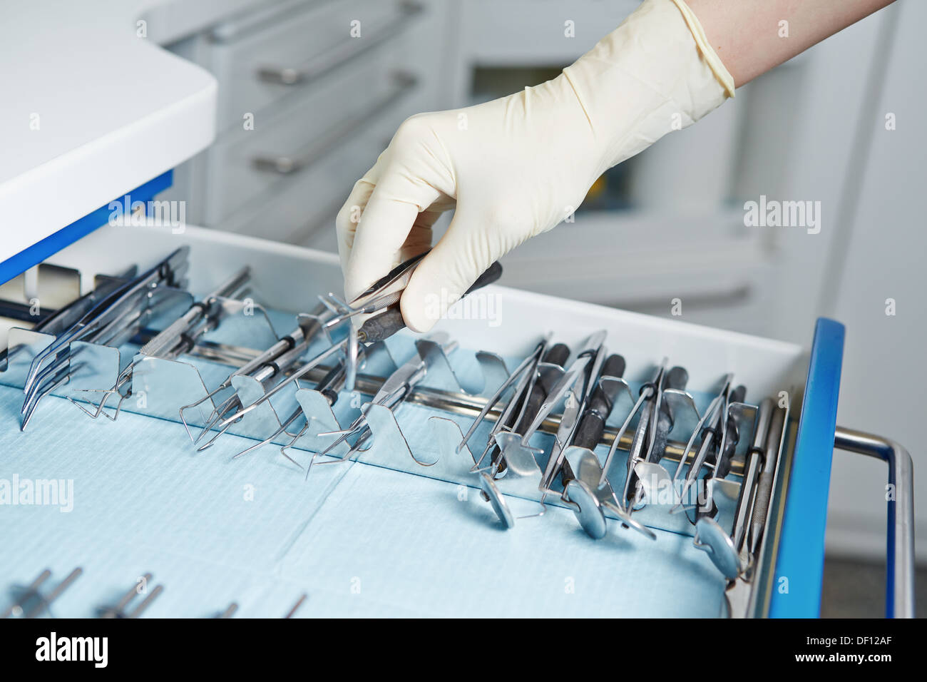 Hand of dentist reaching for different dental tools in a cabinet Stock ...