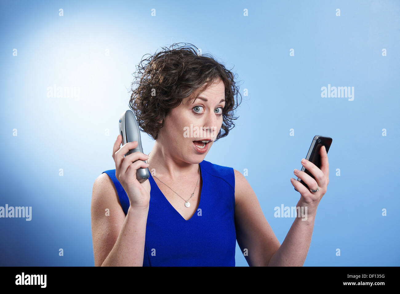 Woman in studio using two mobile phones Stock Photo - Alamy