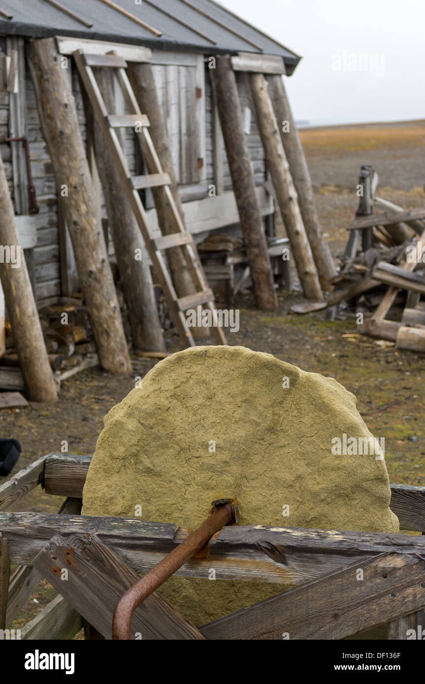 Old grindstone wheel in front of a deserted trapper's hut, Kapp Toscana ...
