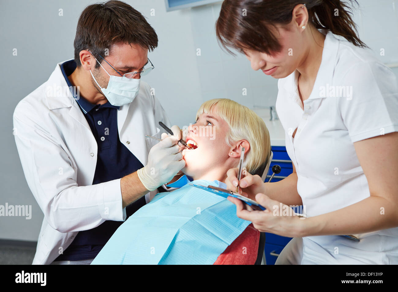 Dental assistant during apprenticeship taking notes at treatment of ...