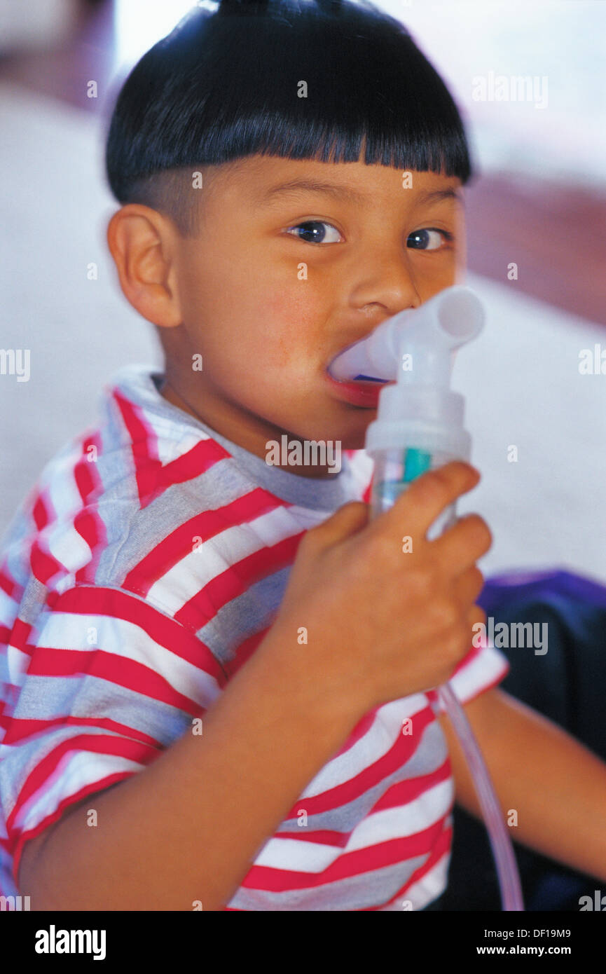 Asthmatic boy using emergency inhaler Stock Photo - Alamy