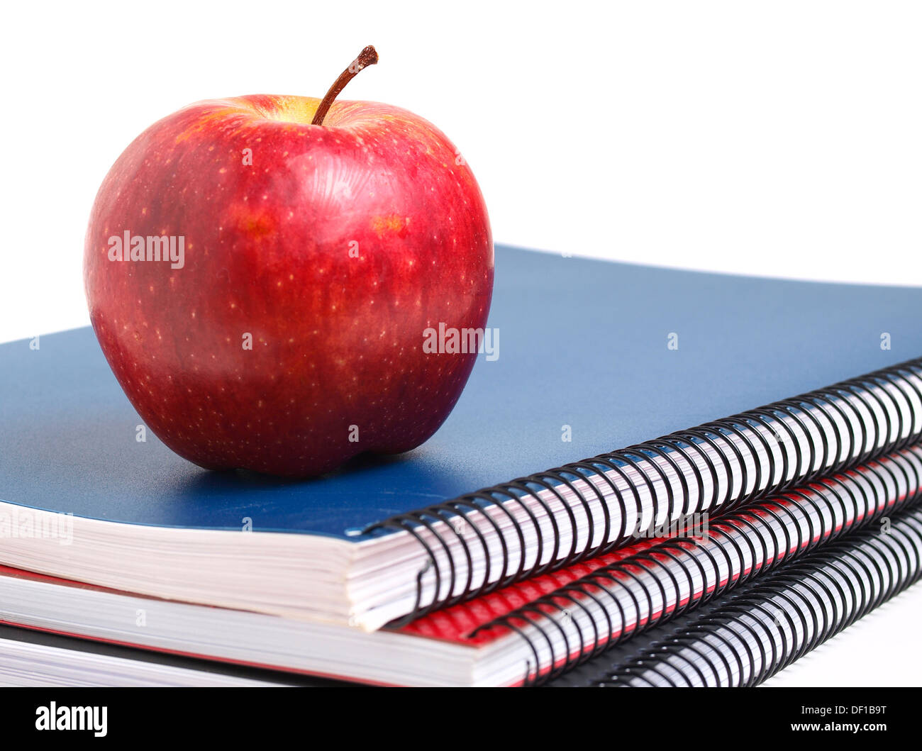 Three notebooks and a red apple isolated on white background Stock ...