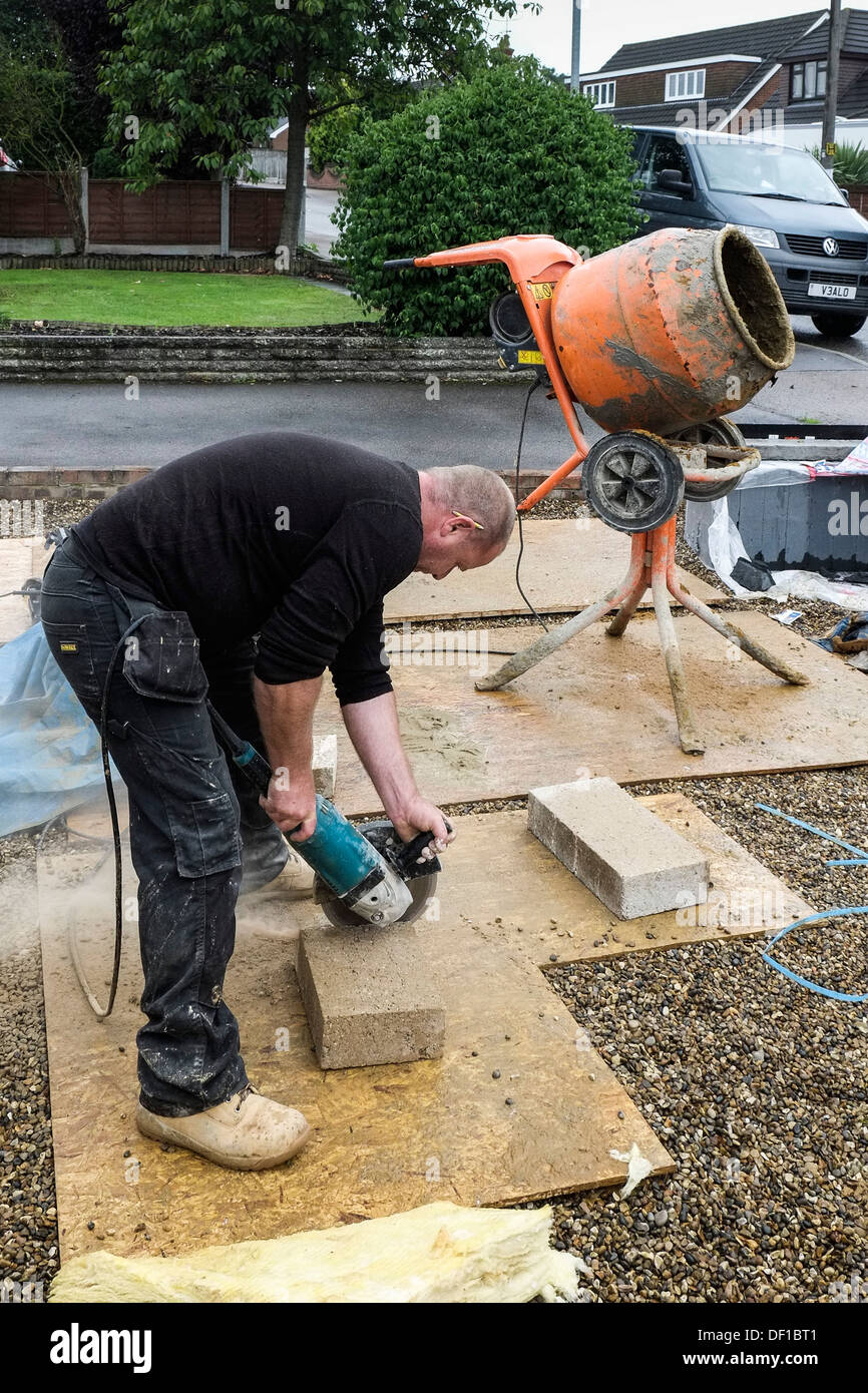 A builder cutting a breeze block with a power tool Stock Photo - Alamy