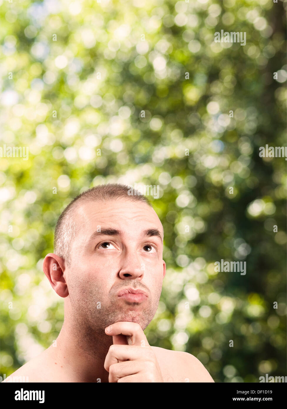 Caucasian man looking up and thinking on nature background Stock Photo ...