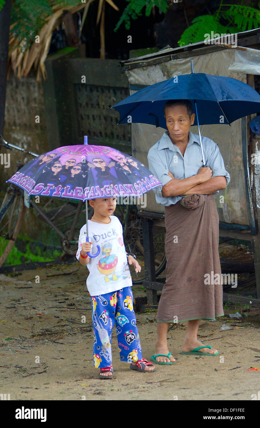 Man and boy stand in the rain in mawlamyine hi-res stock photography ...
