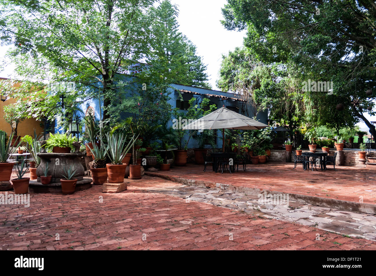 Casual outdoor courtyard, red brick pavers and a bright blue stucco ...