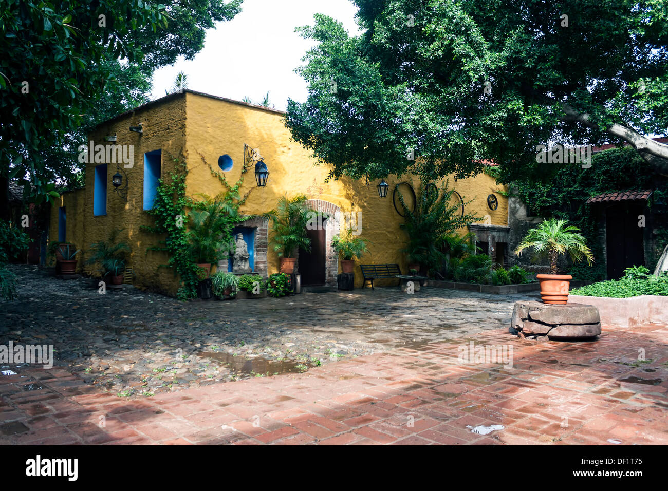 Casual outdoor courtyard, red brick pavers and a bright yellow stucco ...