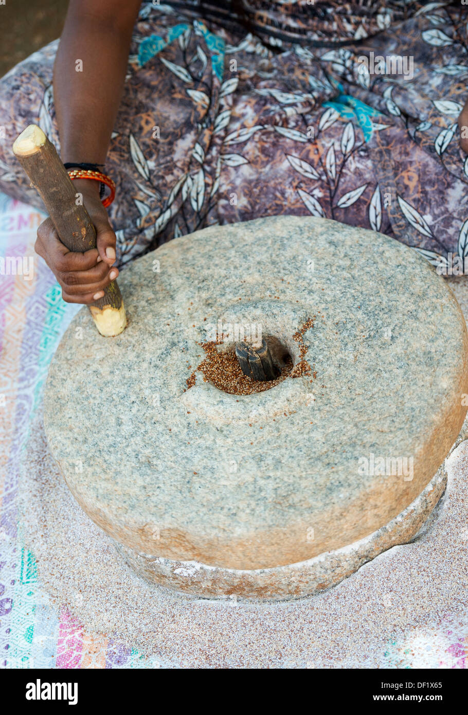 Rural Indian village woman using Quern stones to grind Finger Millet ...