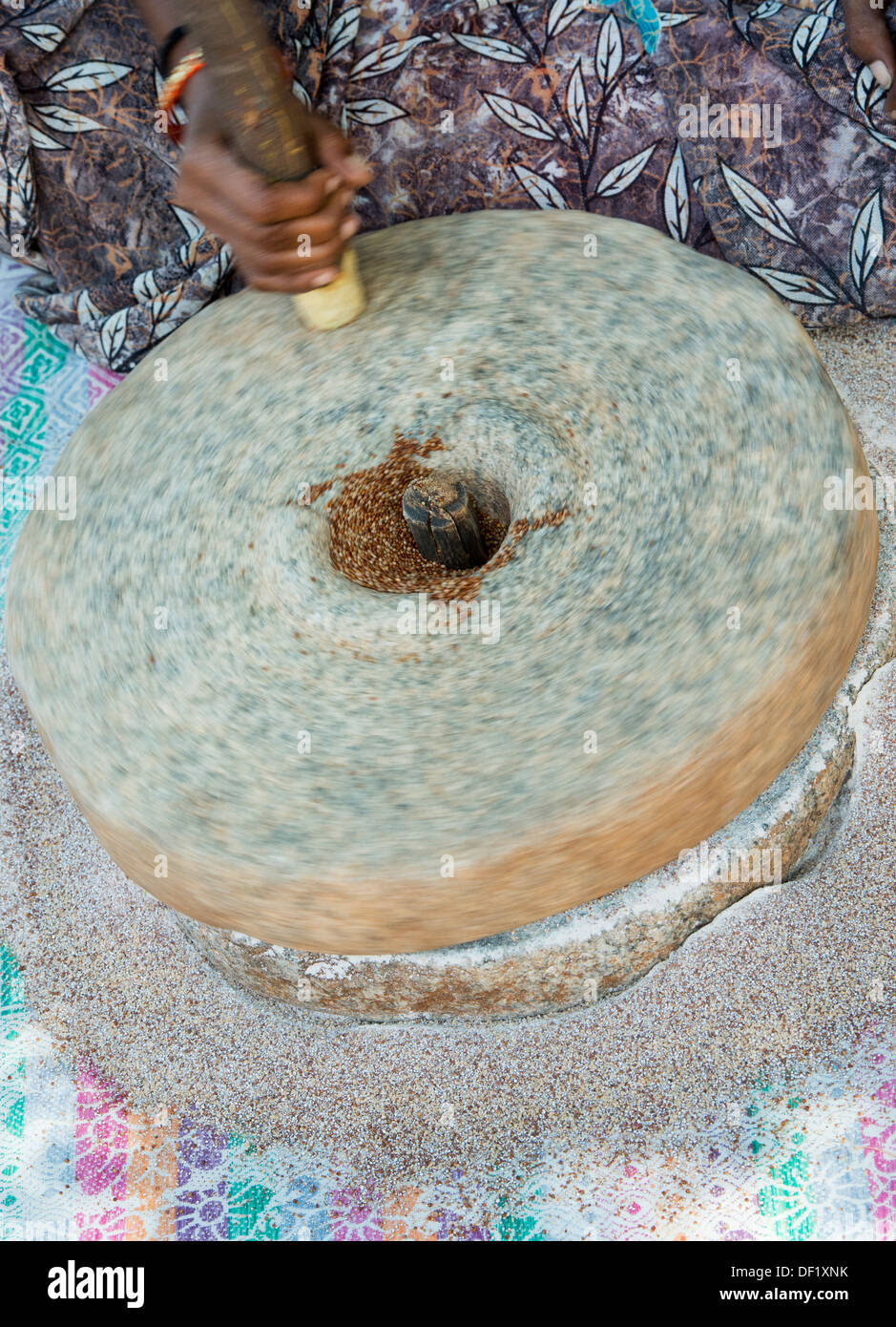 Rural Indian village woman using Quern stones to grind Finger Millet ...